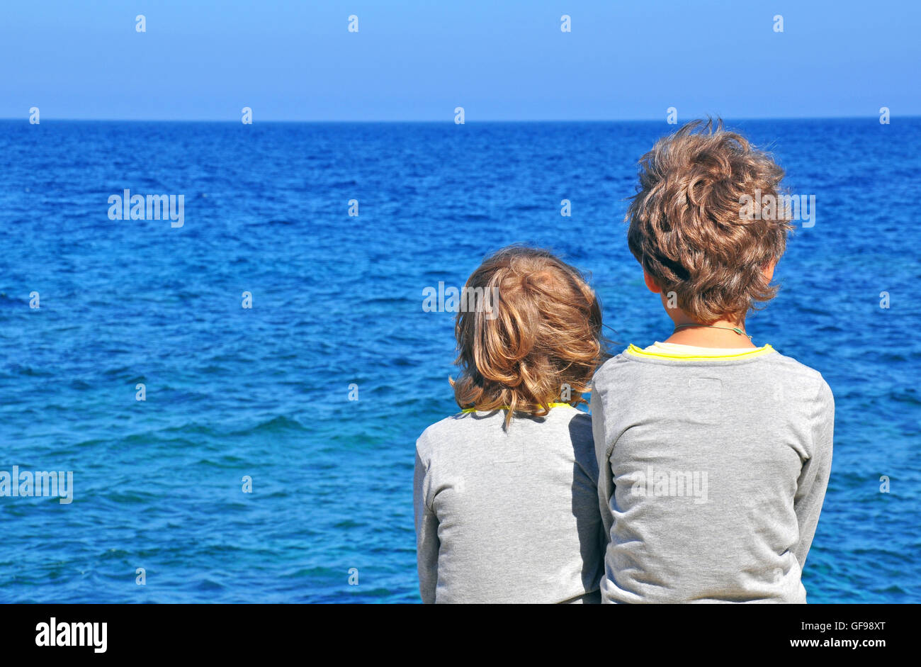 Two boys looking at horizon Stock Photo - Alamy