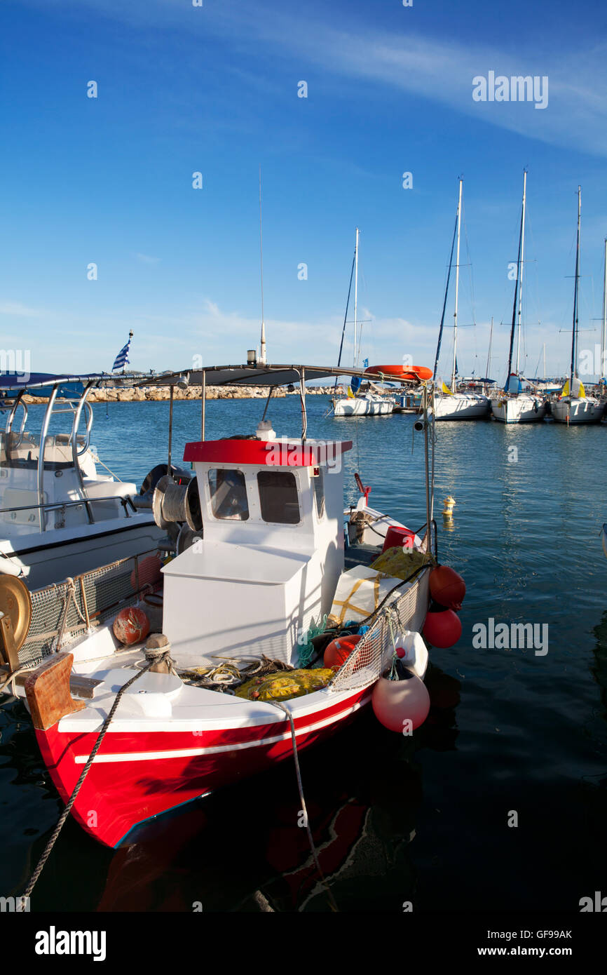 Little fisher boat harbored in front of sailboats in the harbor of ...