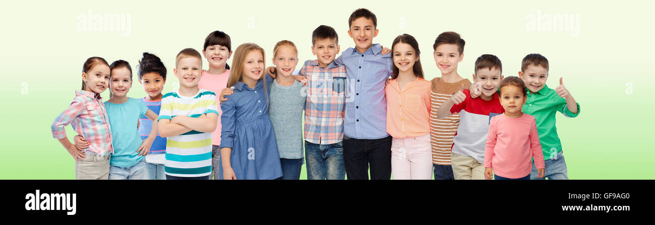 group of happy smiling children hugging over green Stock Photo - Alamy
