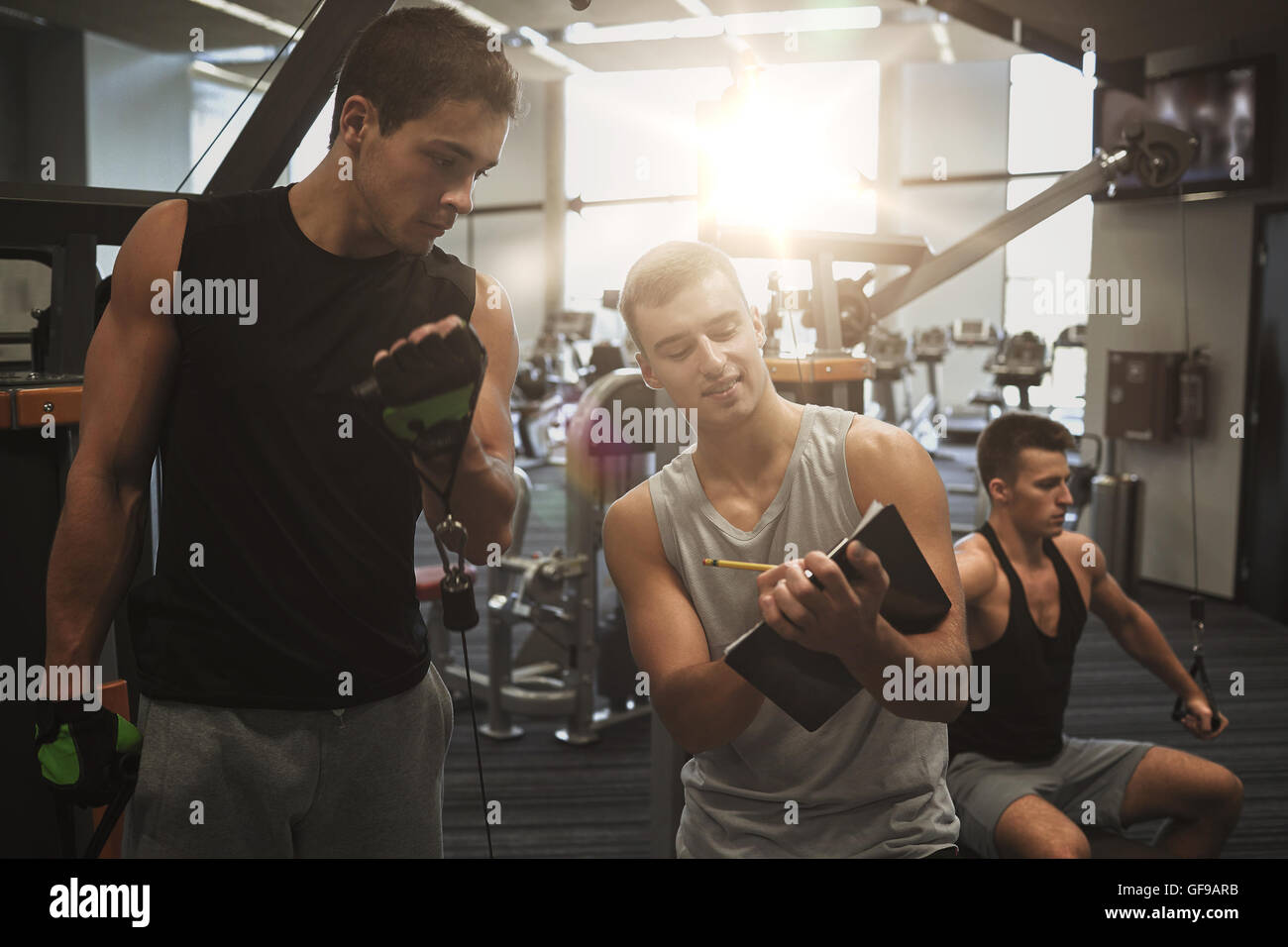 men exercising on gym machine Stock Photo - Alamy