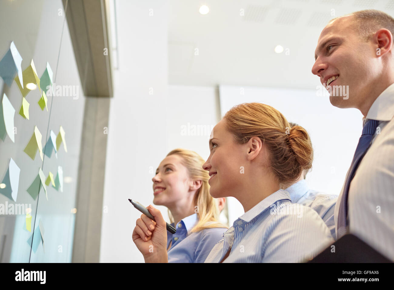 smiling business people with marker and stickers Stock Photo - Alamy