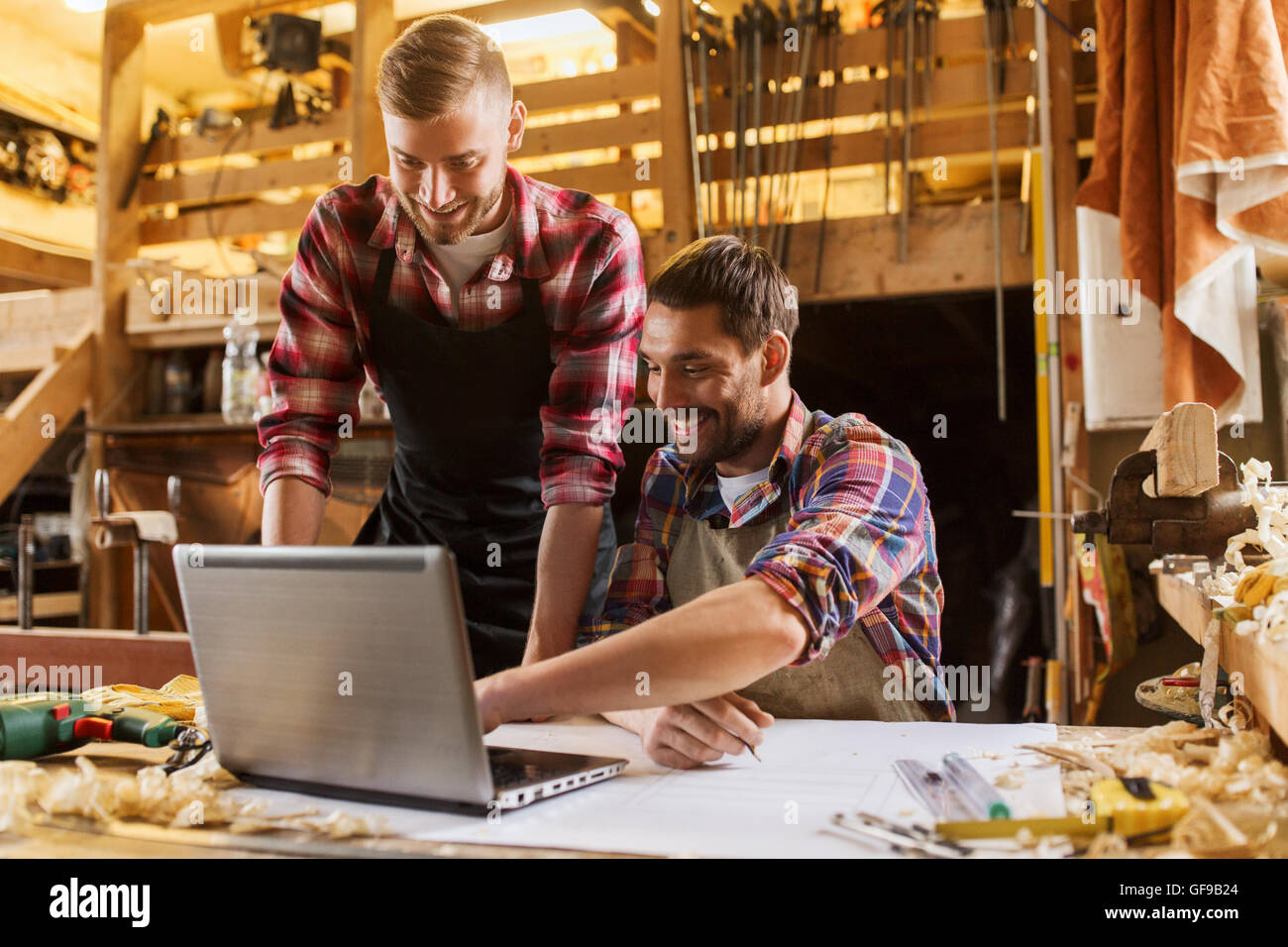 carpenters with laptop and blueprint at workshop Stock Photo - Alamy