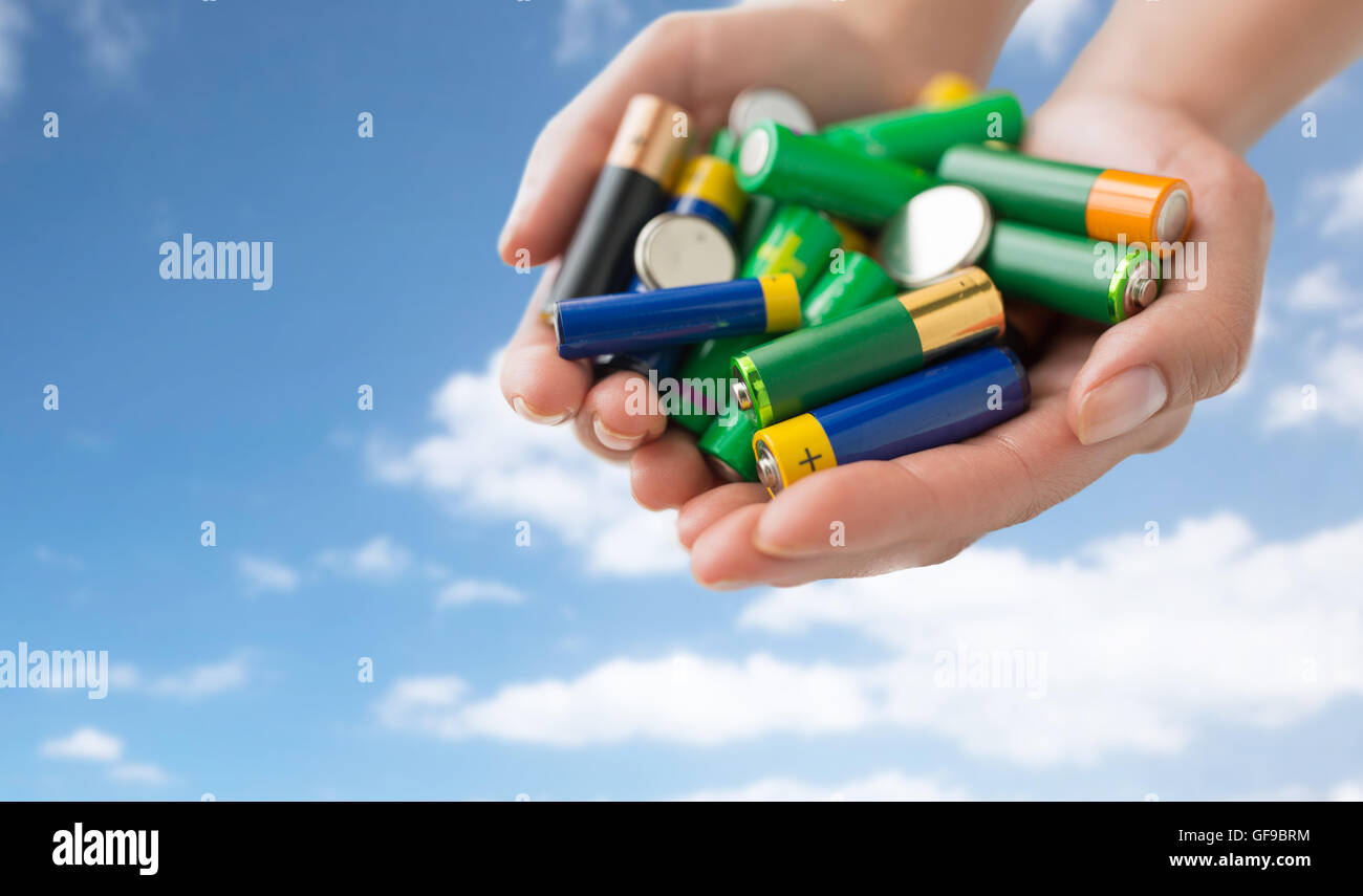 close up of hands holding alkaline batteries heap Stock Photo - Alamy