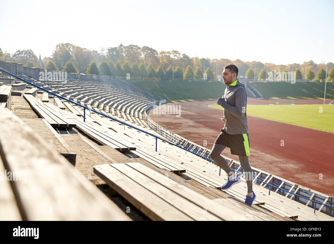 happy young man running upstairs on stadium Stock Photo - Alamy