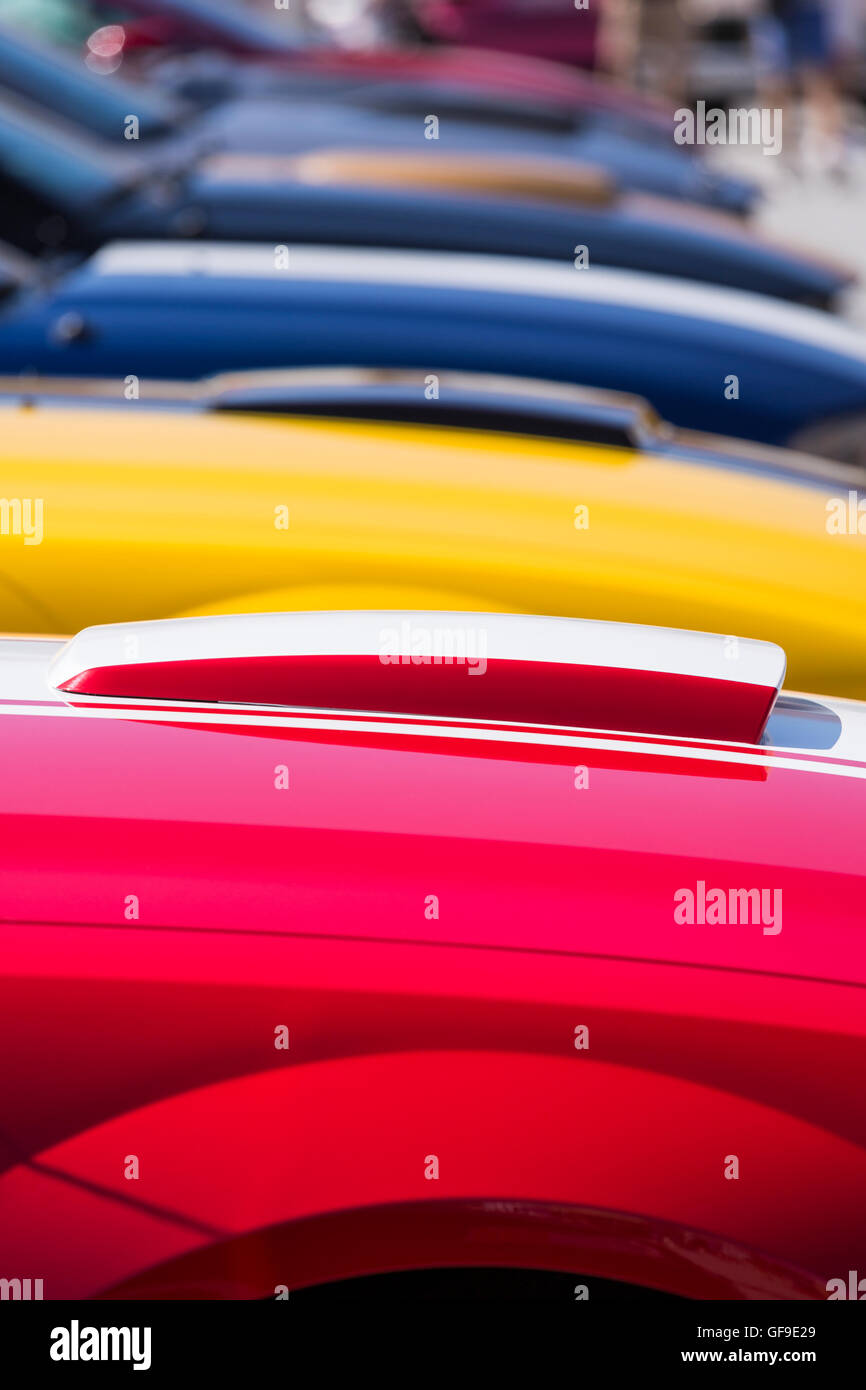 Row of colored Ford Mustang bonnets in red, yellow, blue, parked next ...