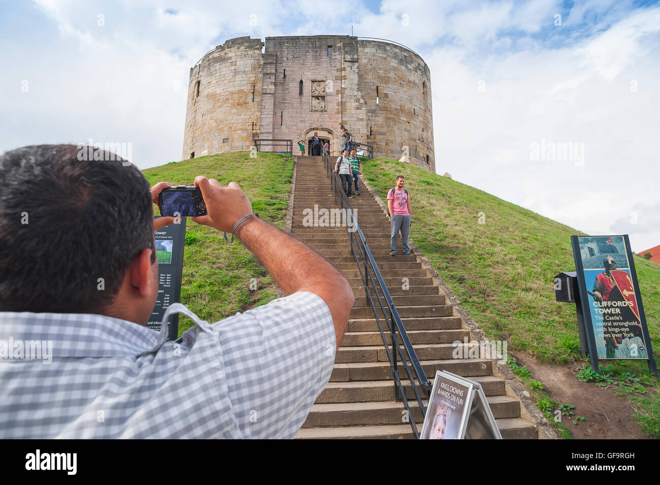 A tourists takes a photo of the Norman keep known as Clifford's Tower ...