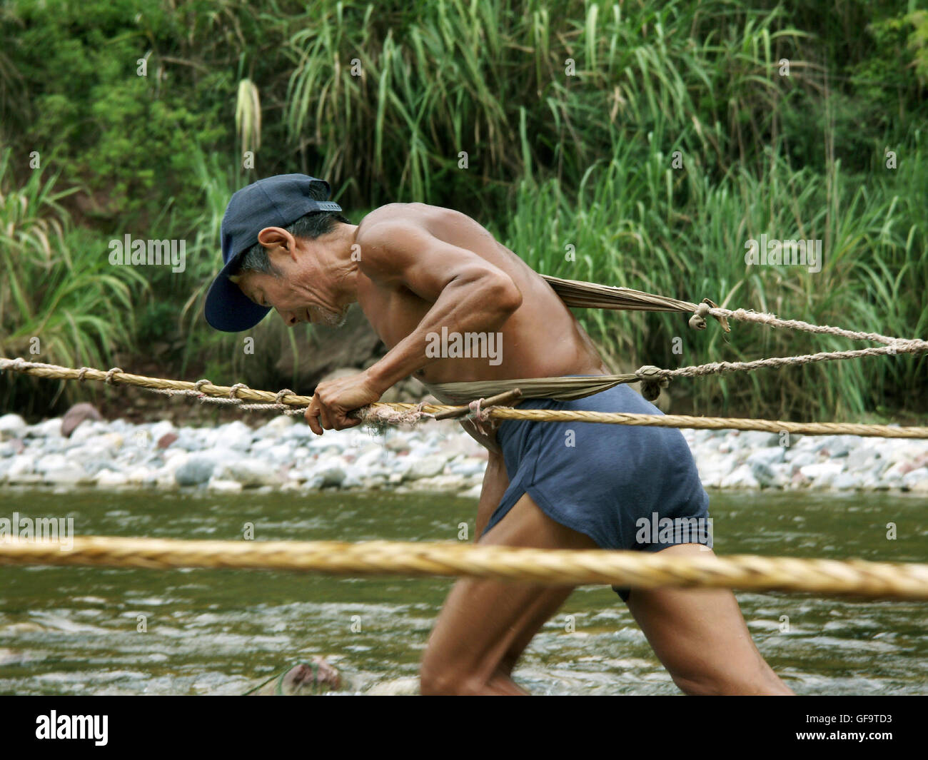 A boatmen of the Tujia minority pulls a “pea boat” carrying tourists ...