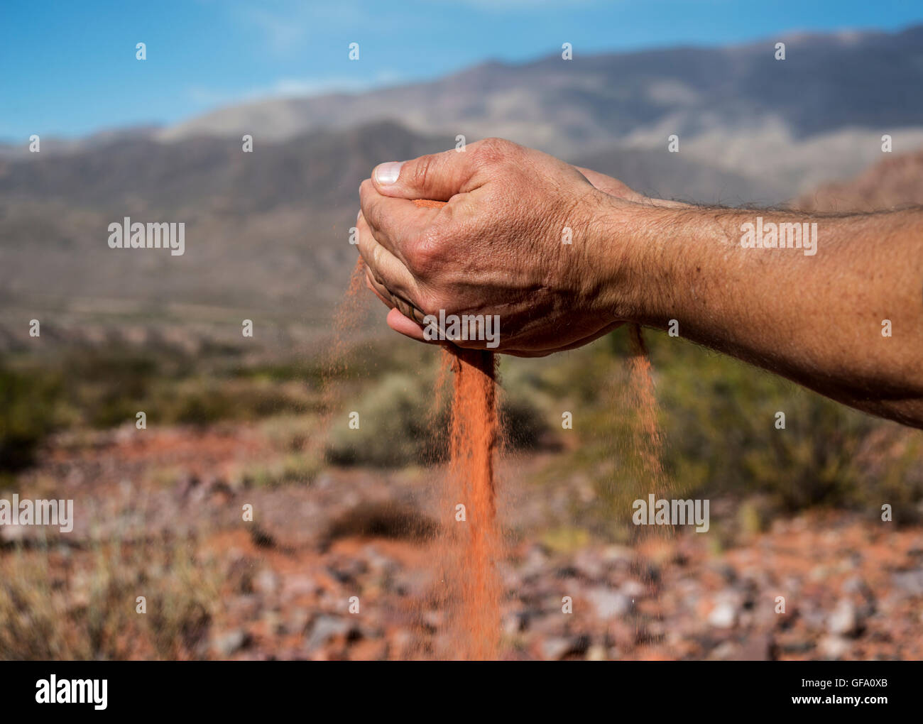Man hands are dropping sand with mountains as background Stock Photo ...