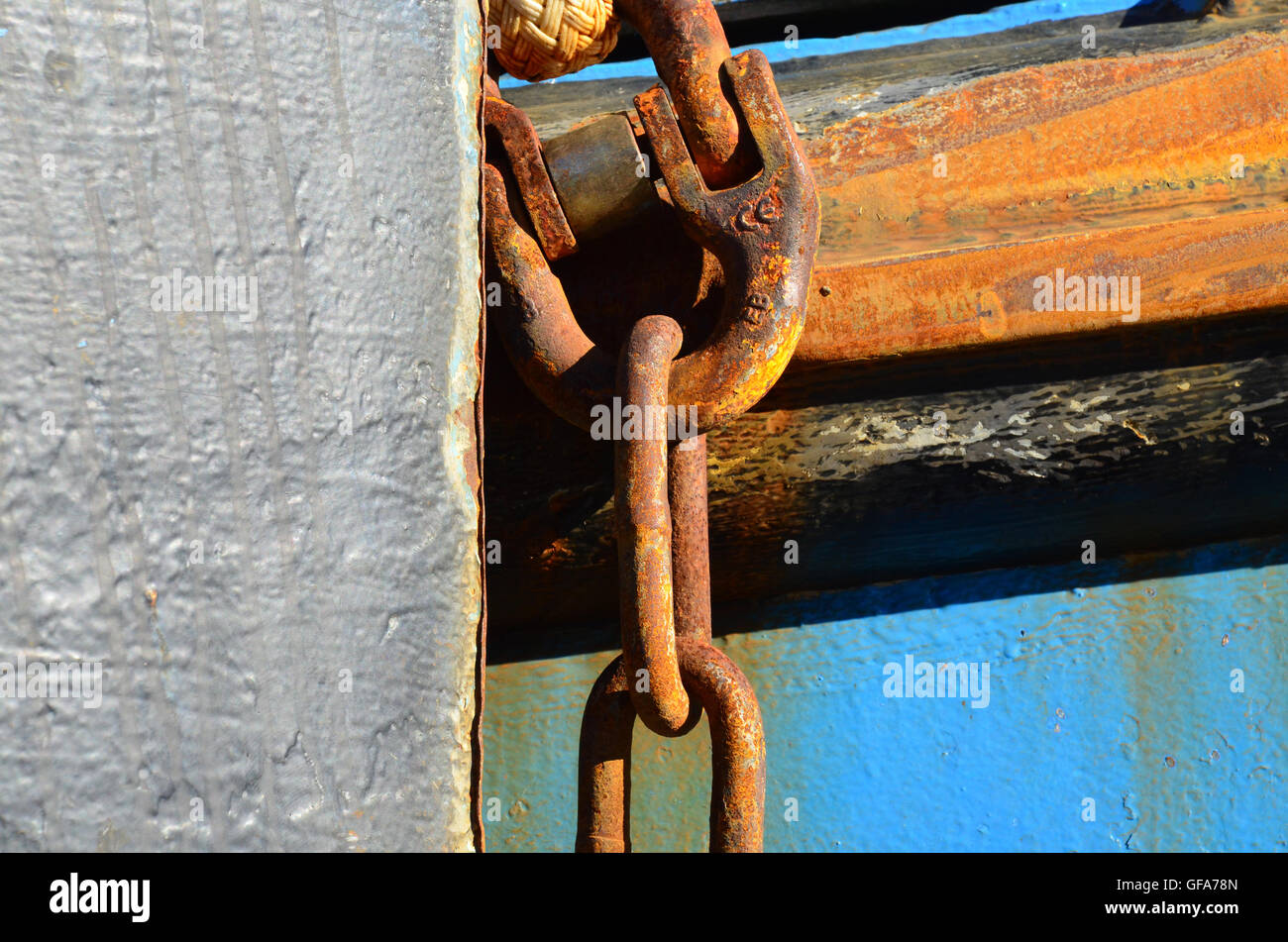 Detail of rusty chain against old painted side of boat Stock Photo - Alamy