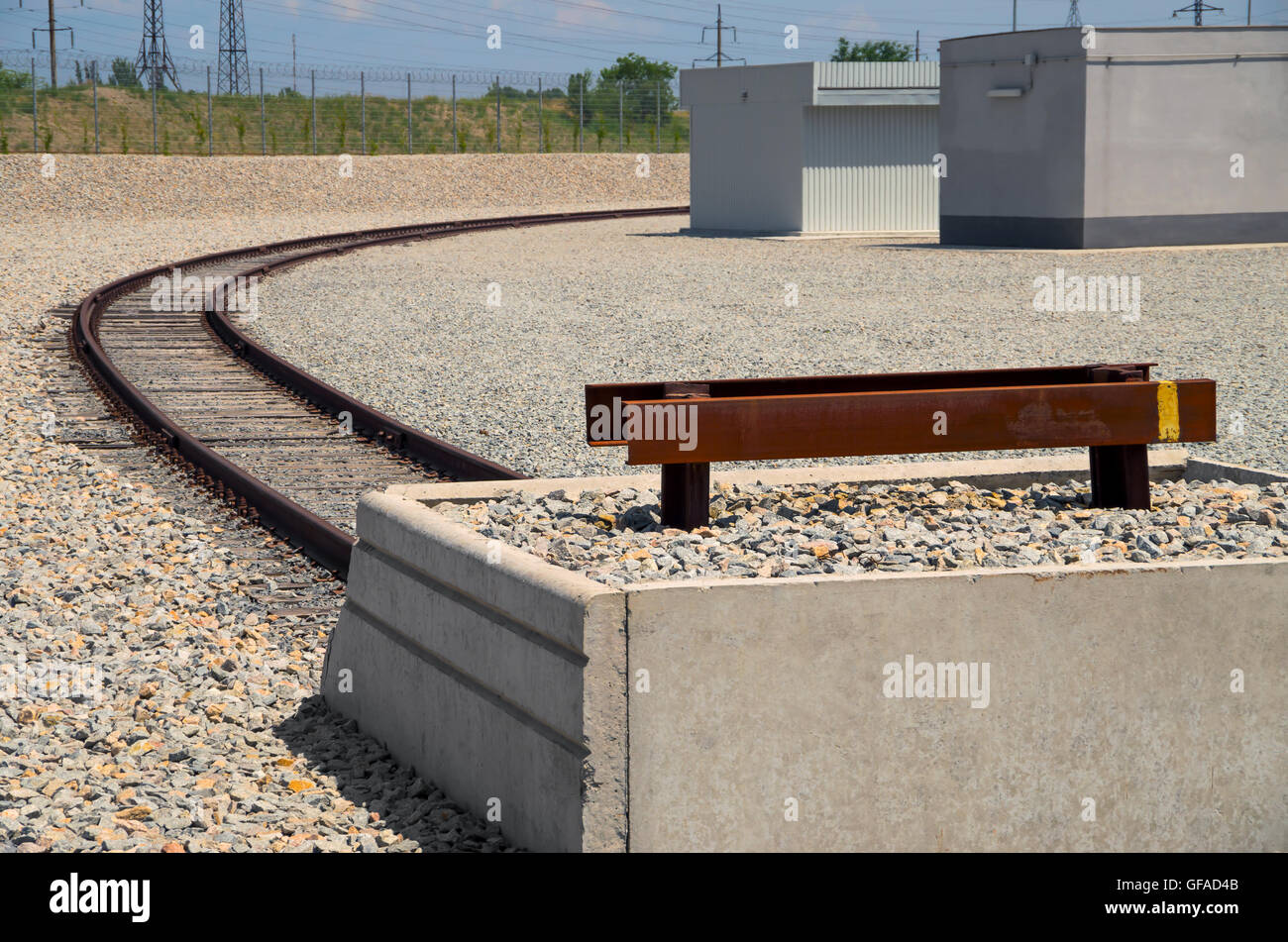 End of rail in an industrial area on background of gravelly embankment ...