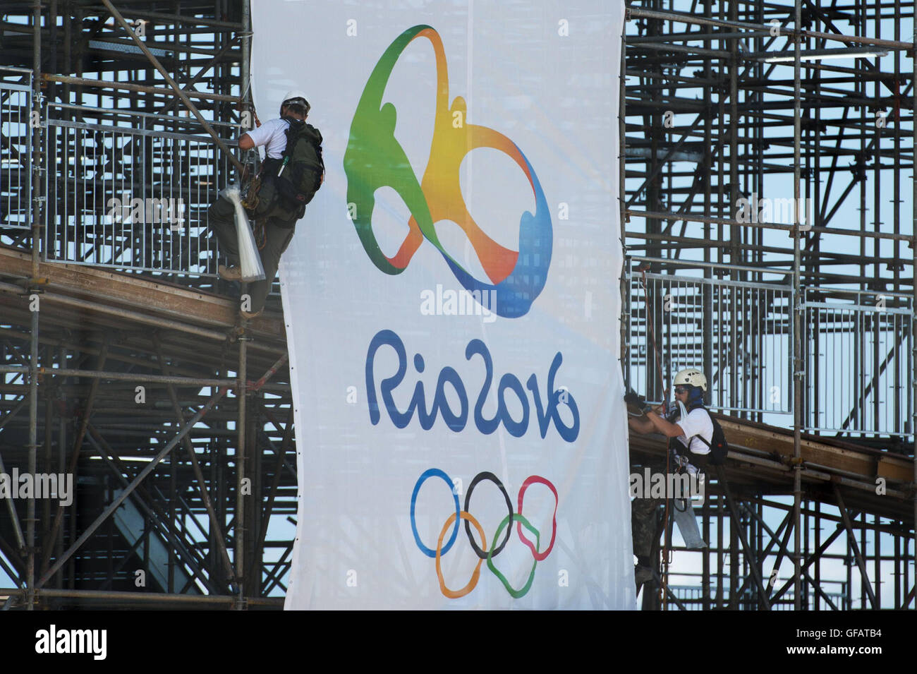 Rio De Janeiro, Brazil. 30th July, 2016. Workers erect a giant banner ...