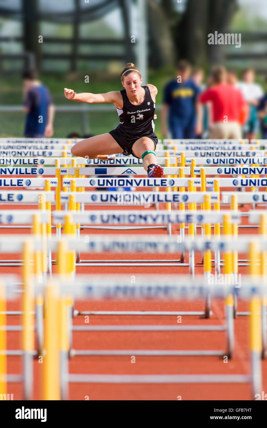 Female hurdler competes during a high school track & field meet Stock ...