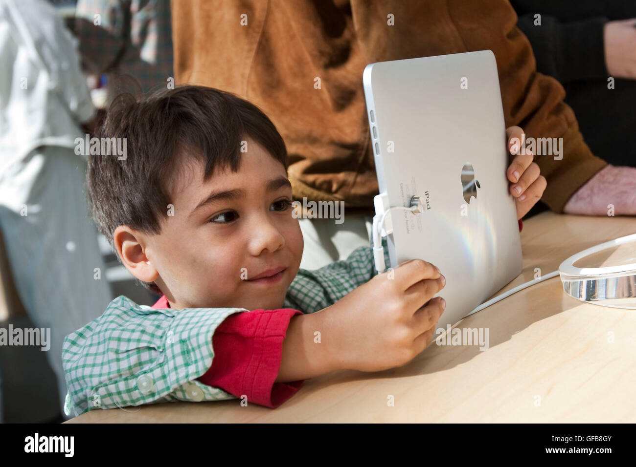 A little boy tries out an Apple iPad device in an Apple store. March ...