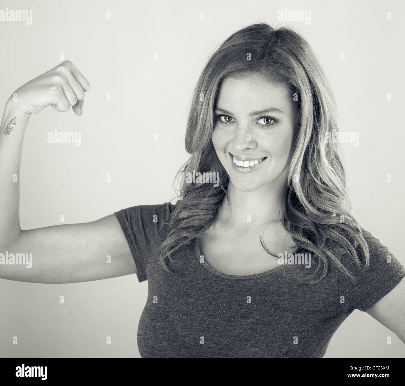 female model attractive woman showing strength with arm curl Stock ...