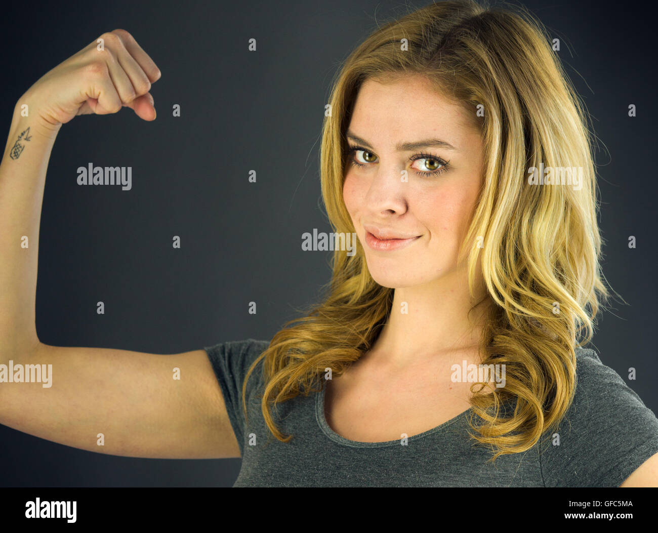 female model attractive woman showing strength with arm curl Stock ...