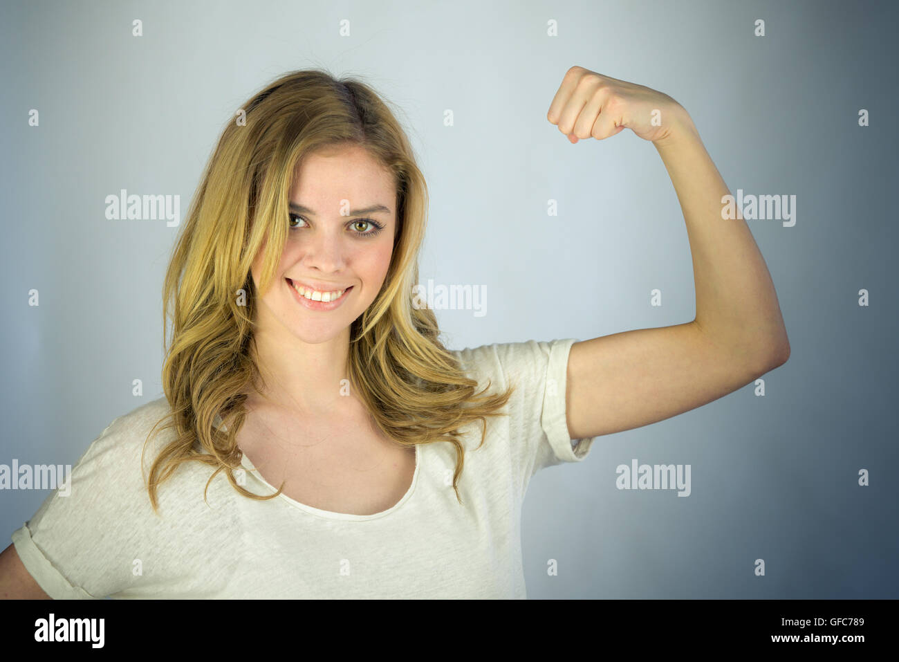 female model attractive woman showing strength with arm curl Stock ...