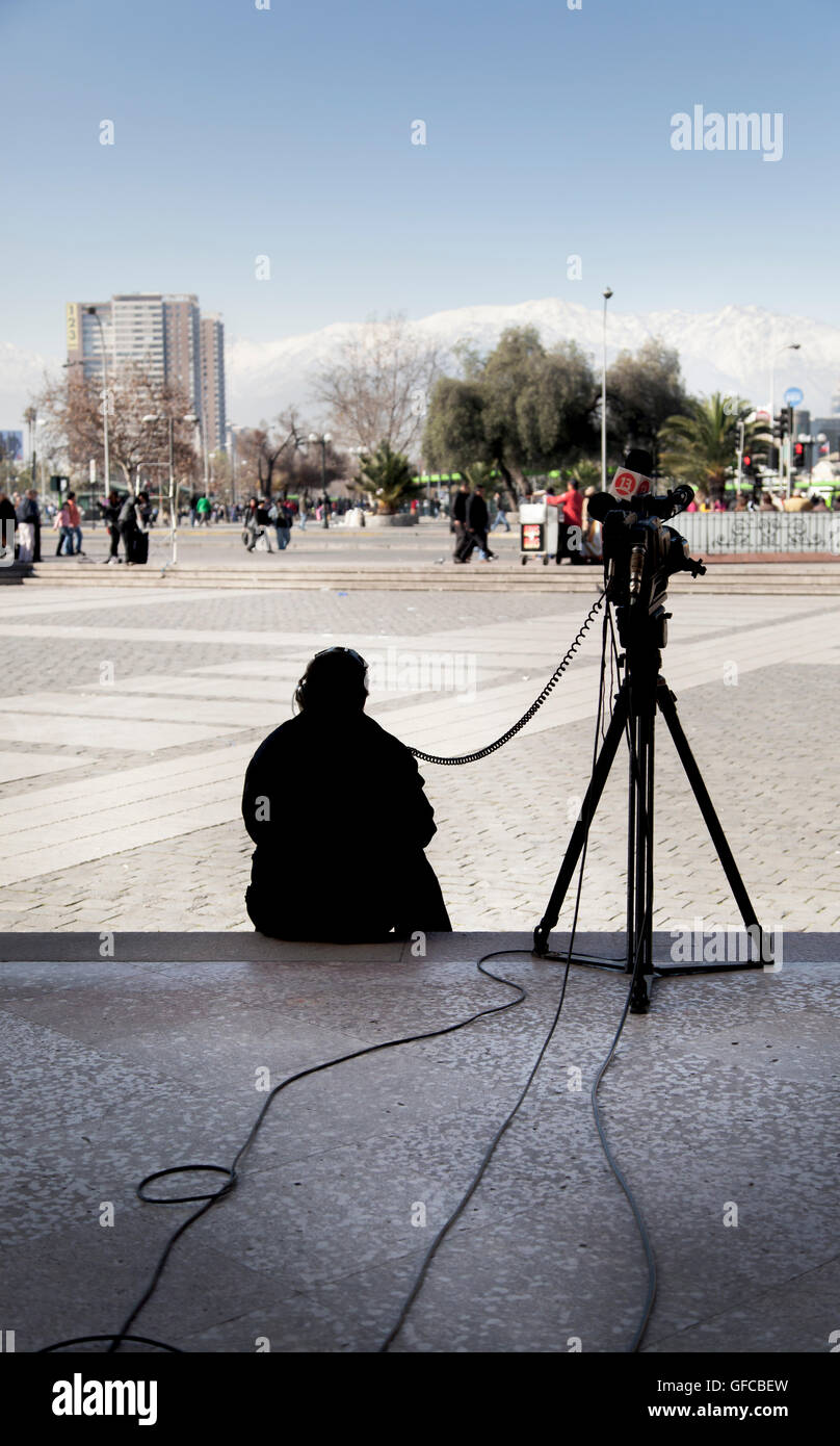 Rear view of a photographer sitting with his camera, Santiago, Chile ...