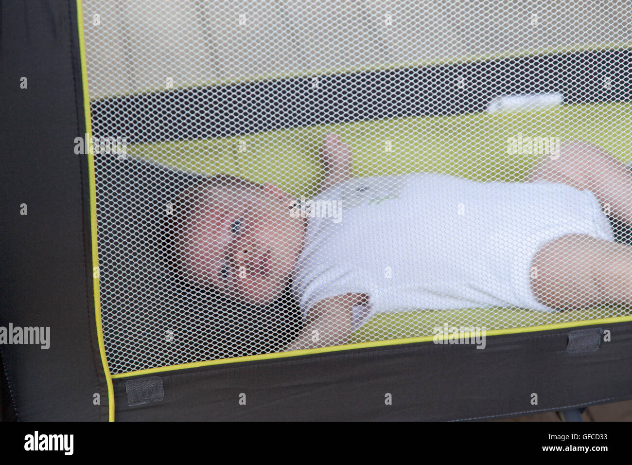 Baby boy lying on the bed covered with mosquito net Stock Photo - Alamy
