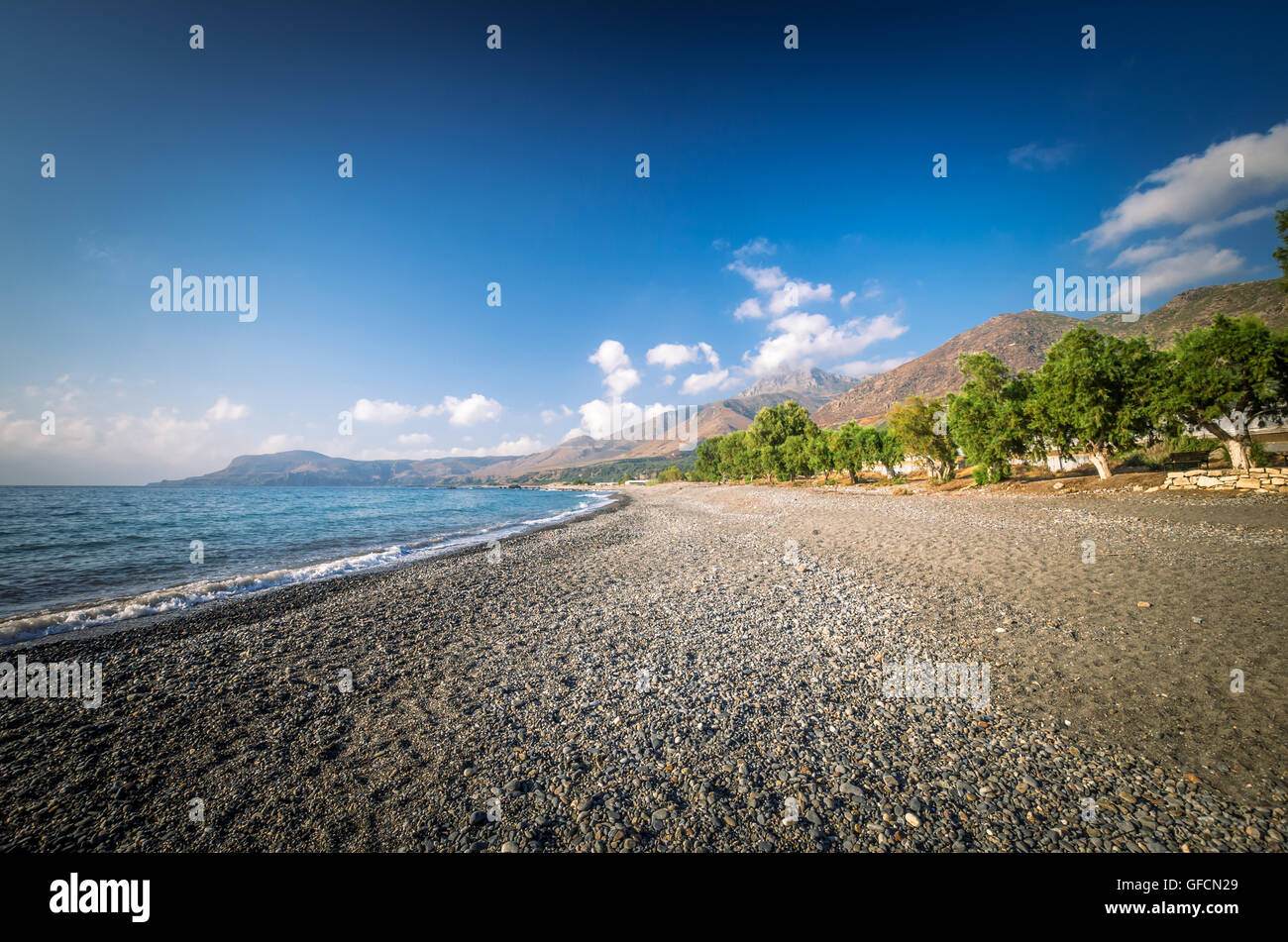 Sfinari Beach in Crete island, Greece. Straw parasols and sunbeds on ...