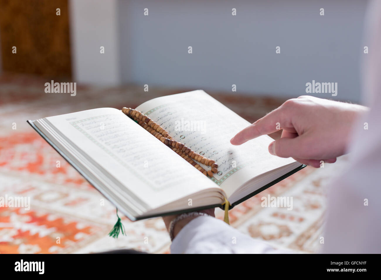 a muslim man is reading quran Stock Photo - Alamy