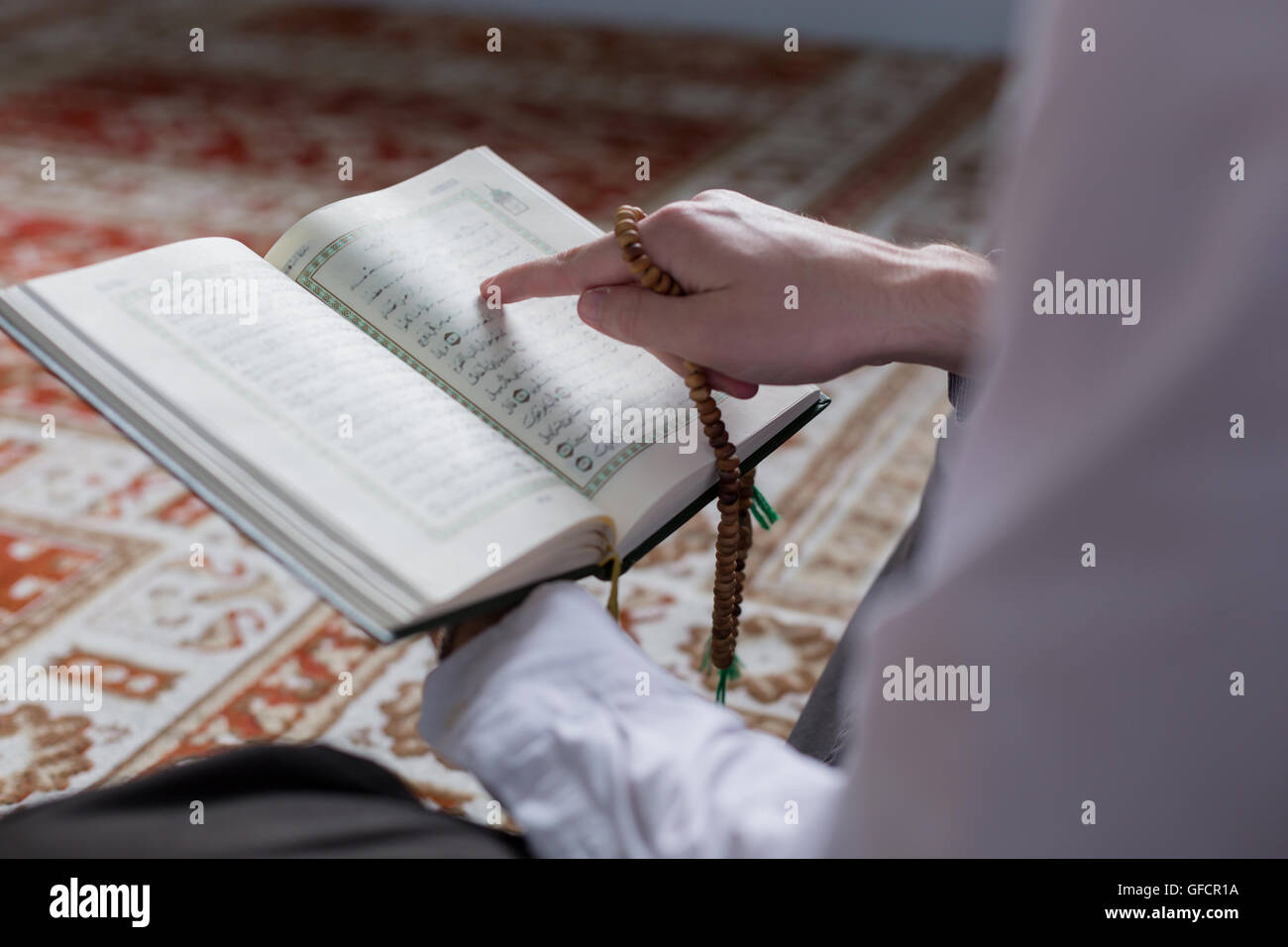 a muslim man is reading quran Stock Photo - Alamy