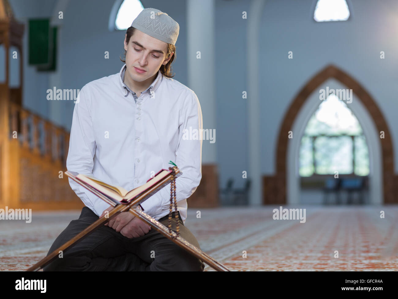 a muslim man is reading quran Stock Photo - Alamy