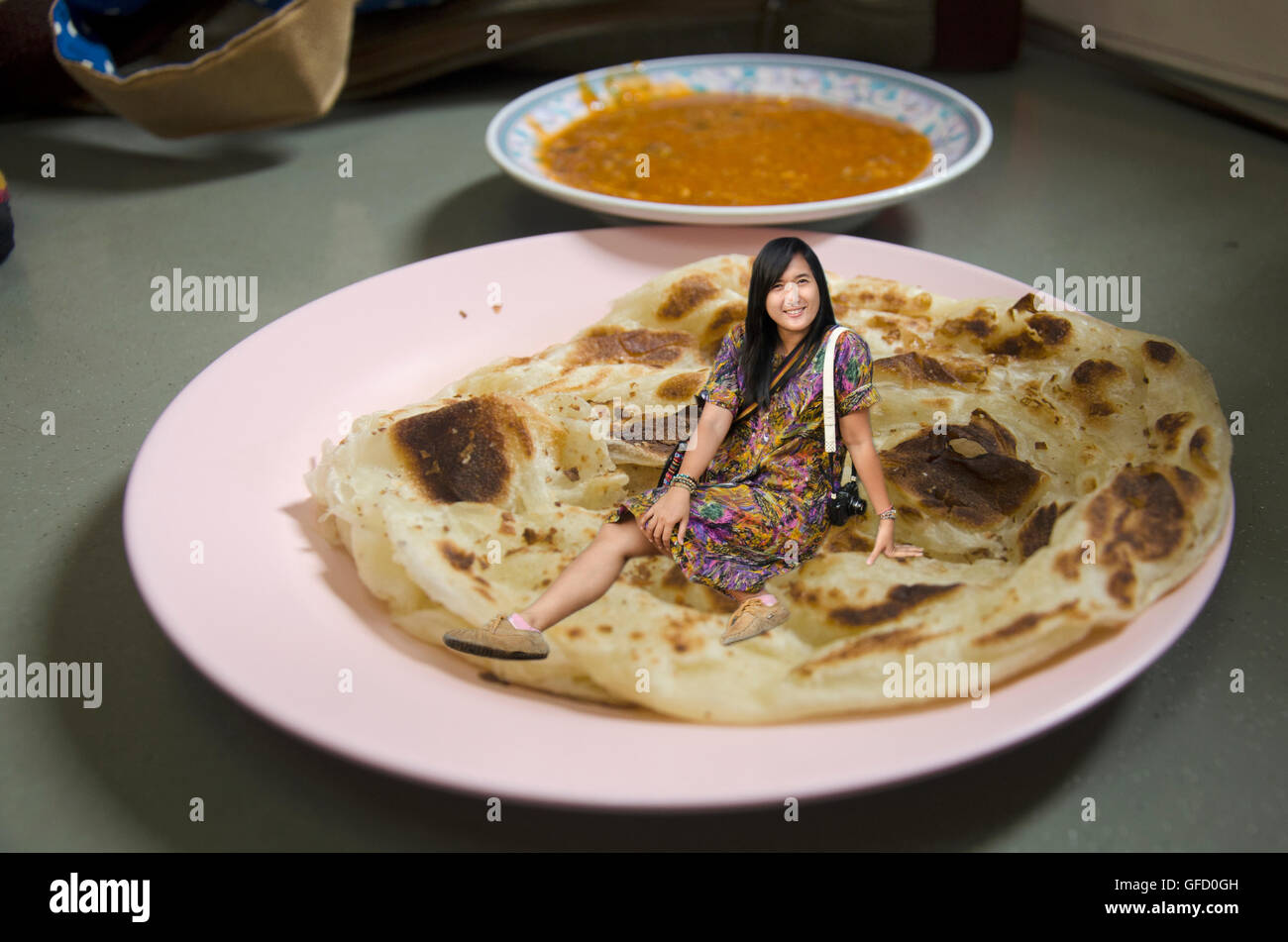 Small people sitting on Big roti mataba with tuna massaman curry Stock ...