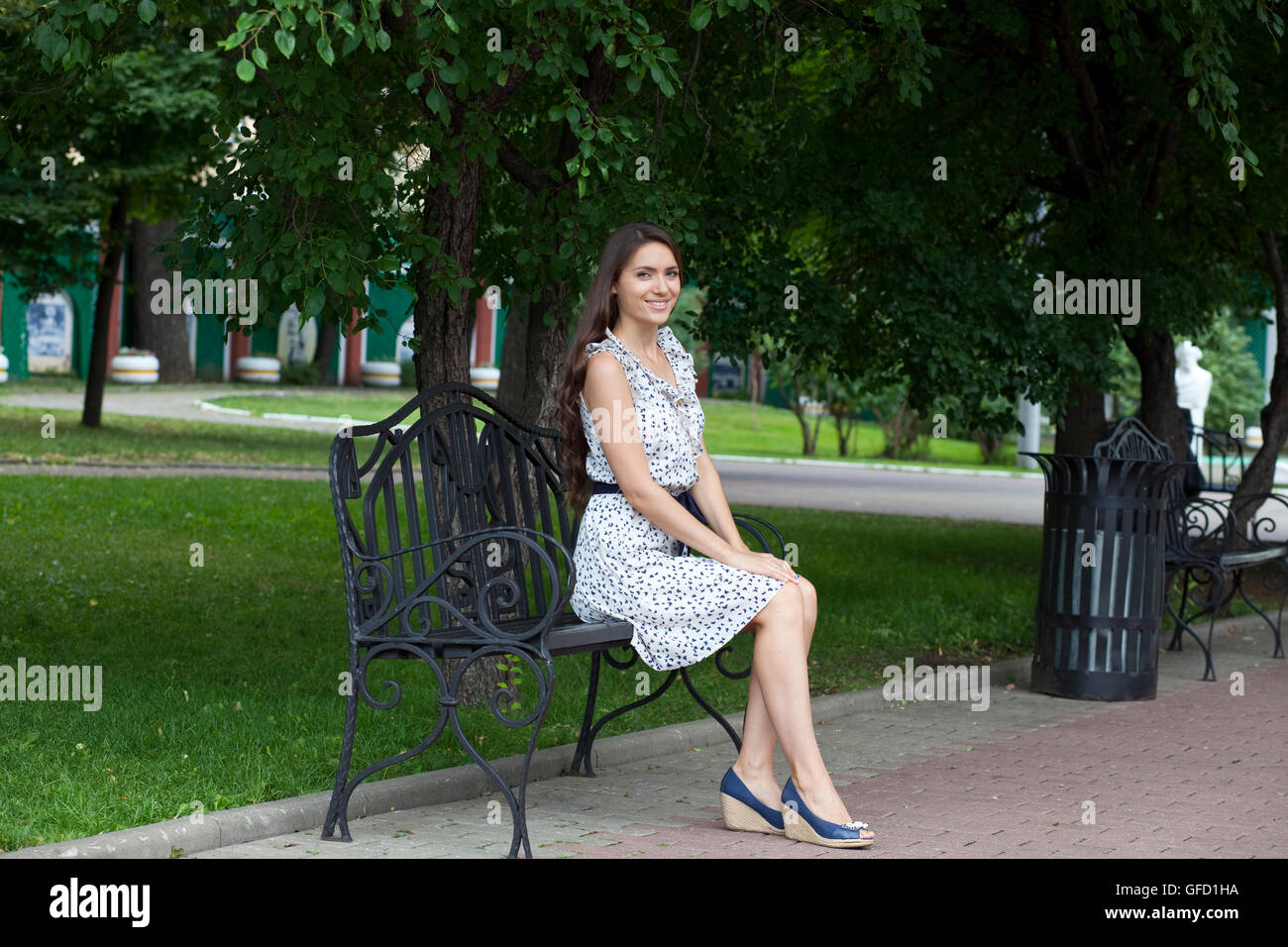Beautiful young woman sits on a bench Stock Photo - Alamy
