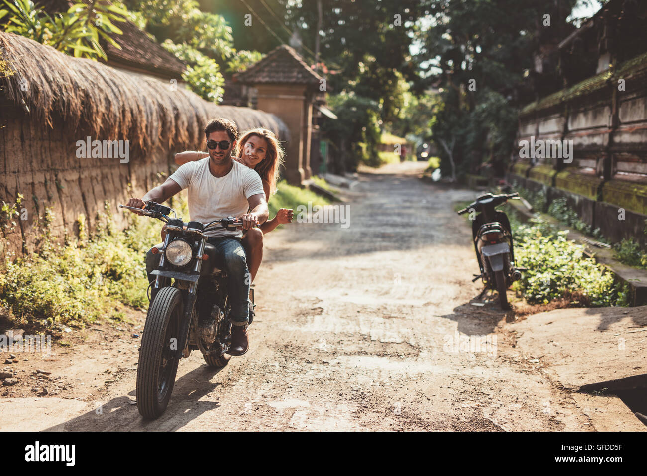 Shot of young couple on motorcycle on country road. Man riding on a ...