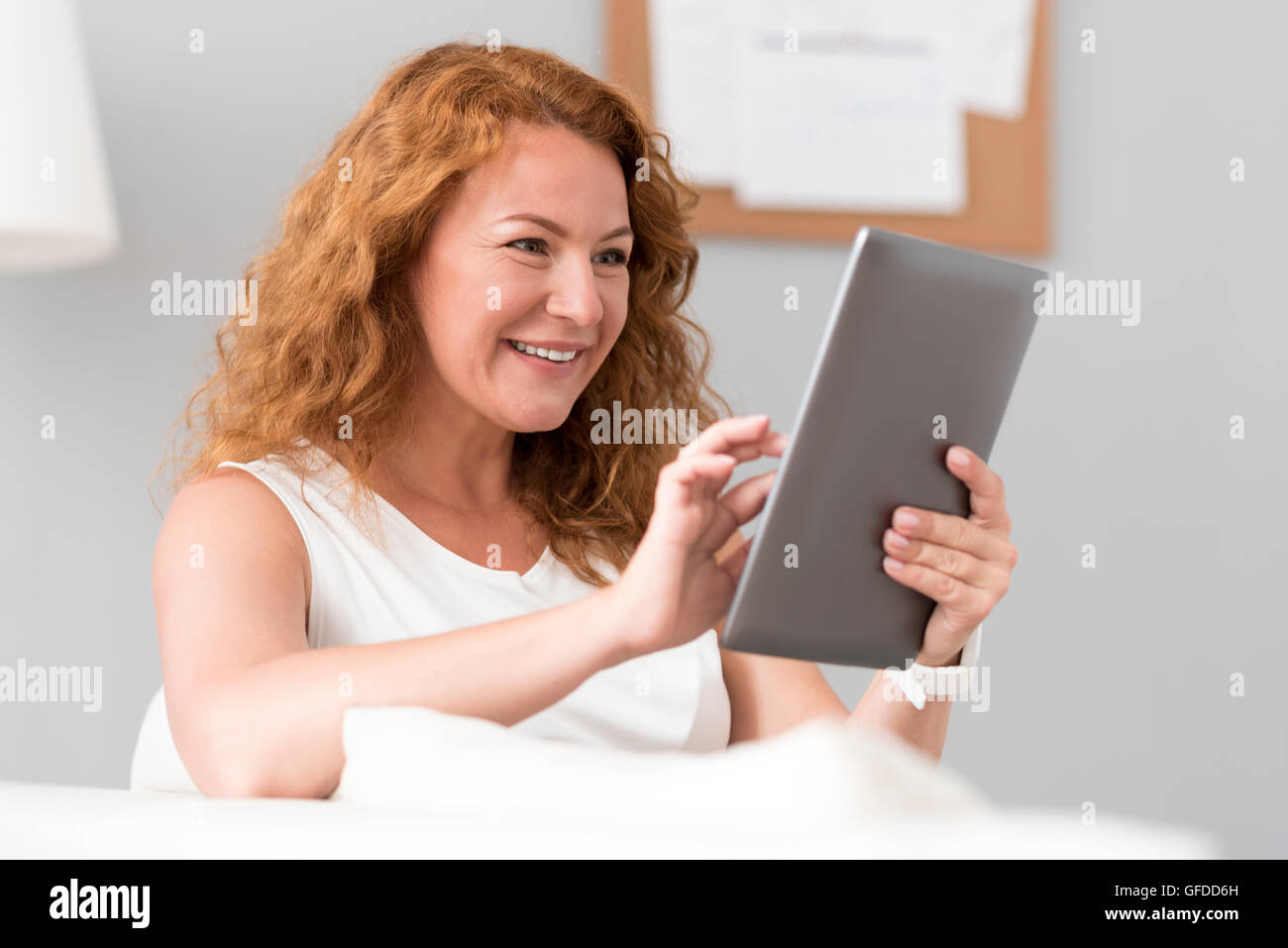 Positive woman using tablet Stock Photo - Alamy