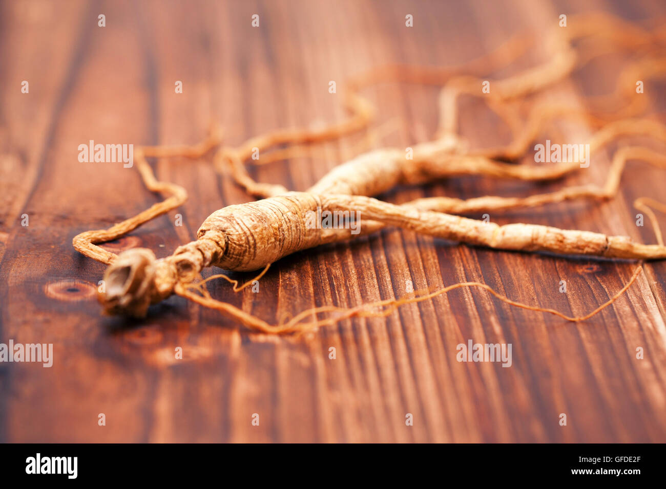 Dry Ginseng on a wood background Stock Photo - Alamy