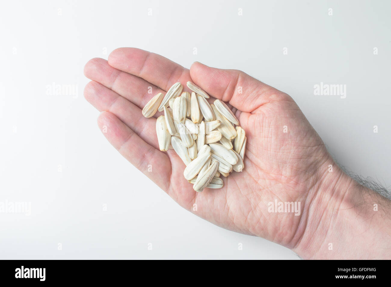 Sunflower seed in a man's hand isolated on white background Stock Photo ...