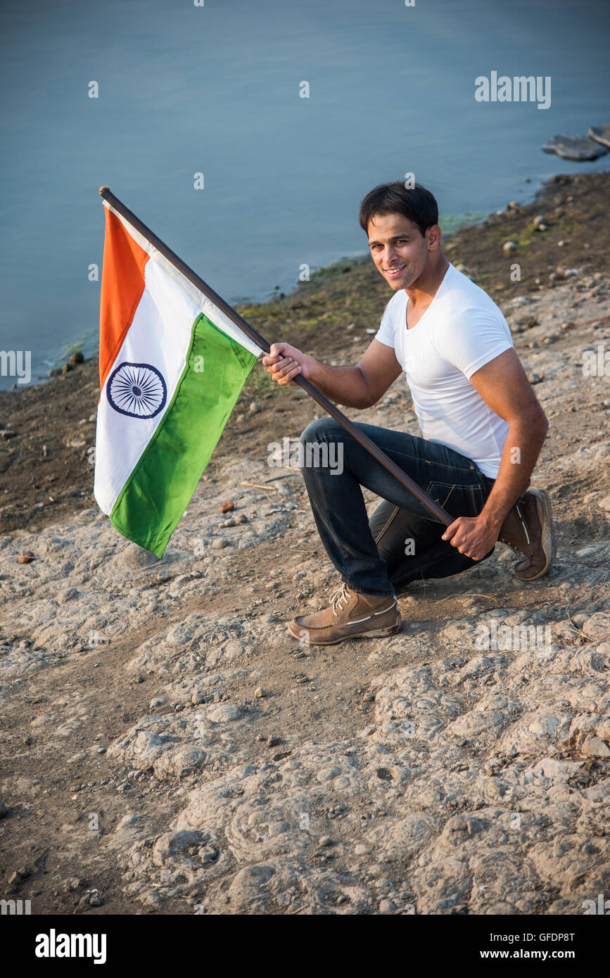 indian young man holding and waving indian flag, conceptual image for ...