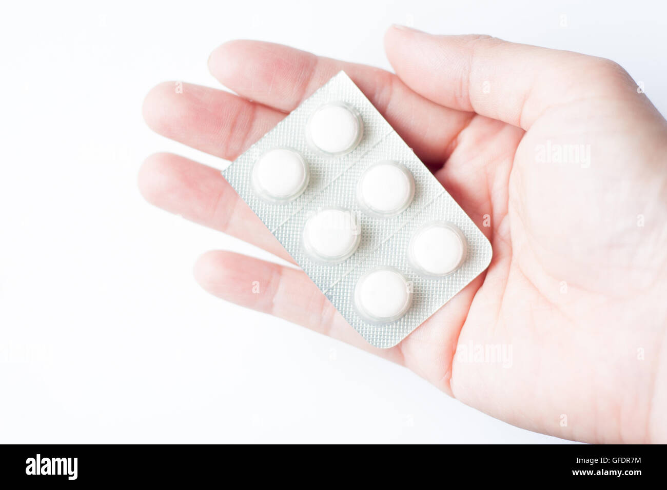 Holding medicine in pill form by hand on white isolate background Stock ...