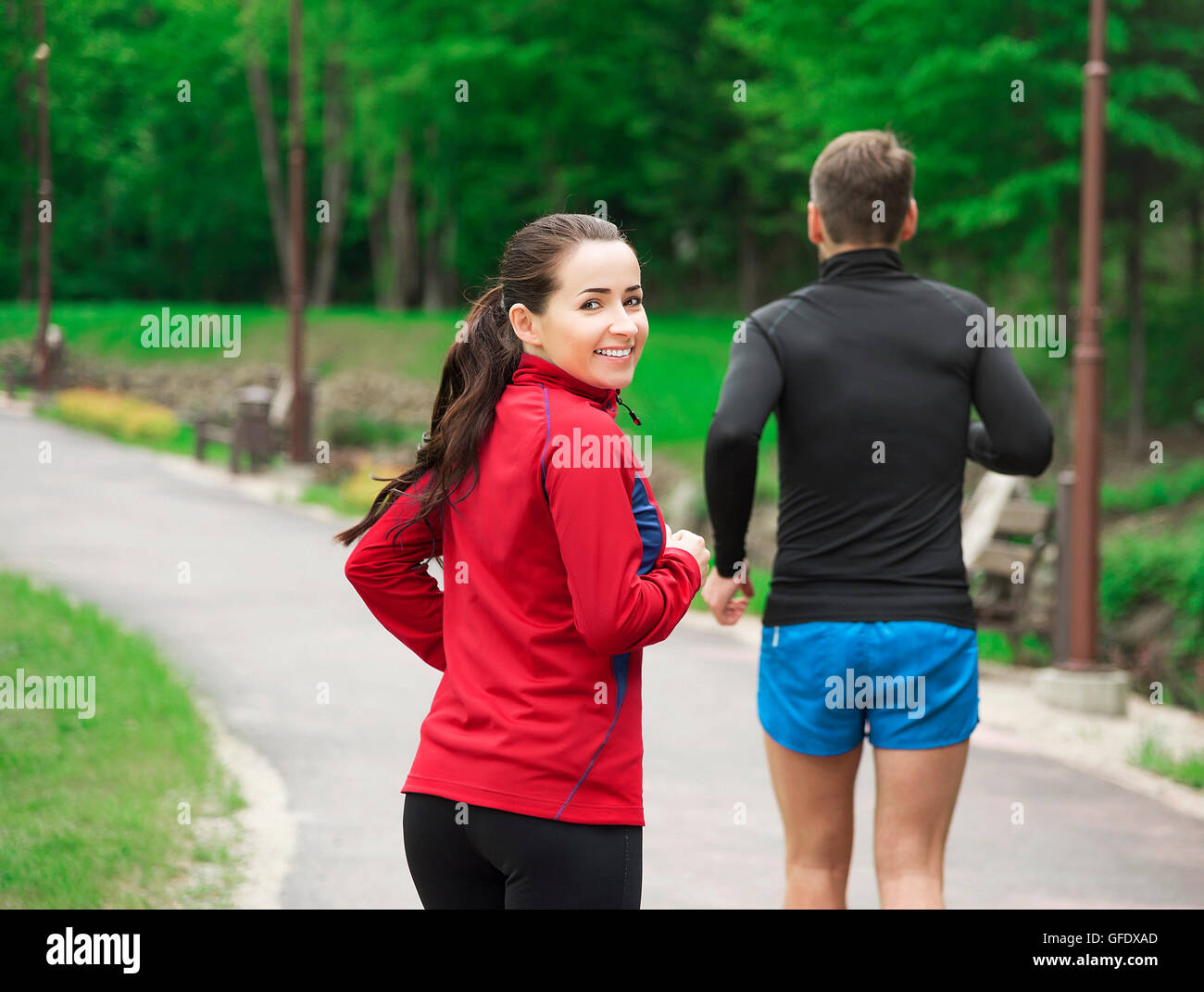 Attractive caucasian couple friends running in park Stock Photo - Alamy