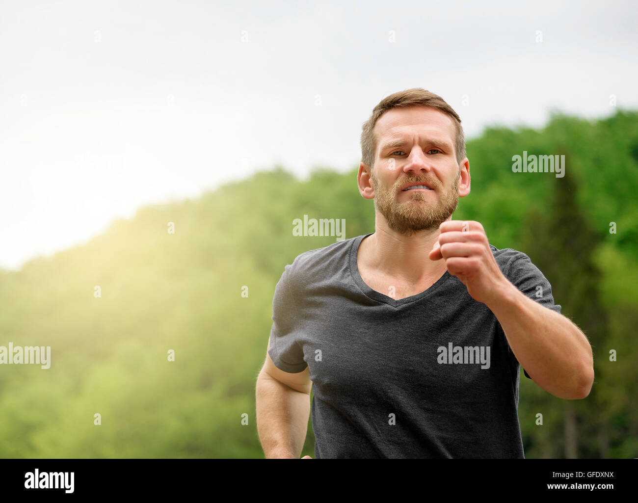 Man running outdoors closeup at sunset. Male athlete jogging outside in ...