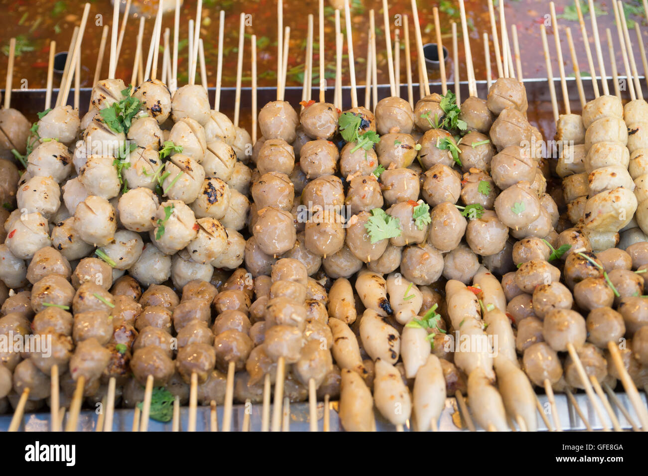 Meatballs on sticks, dipped in sweet chili sauce at a market in ...