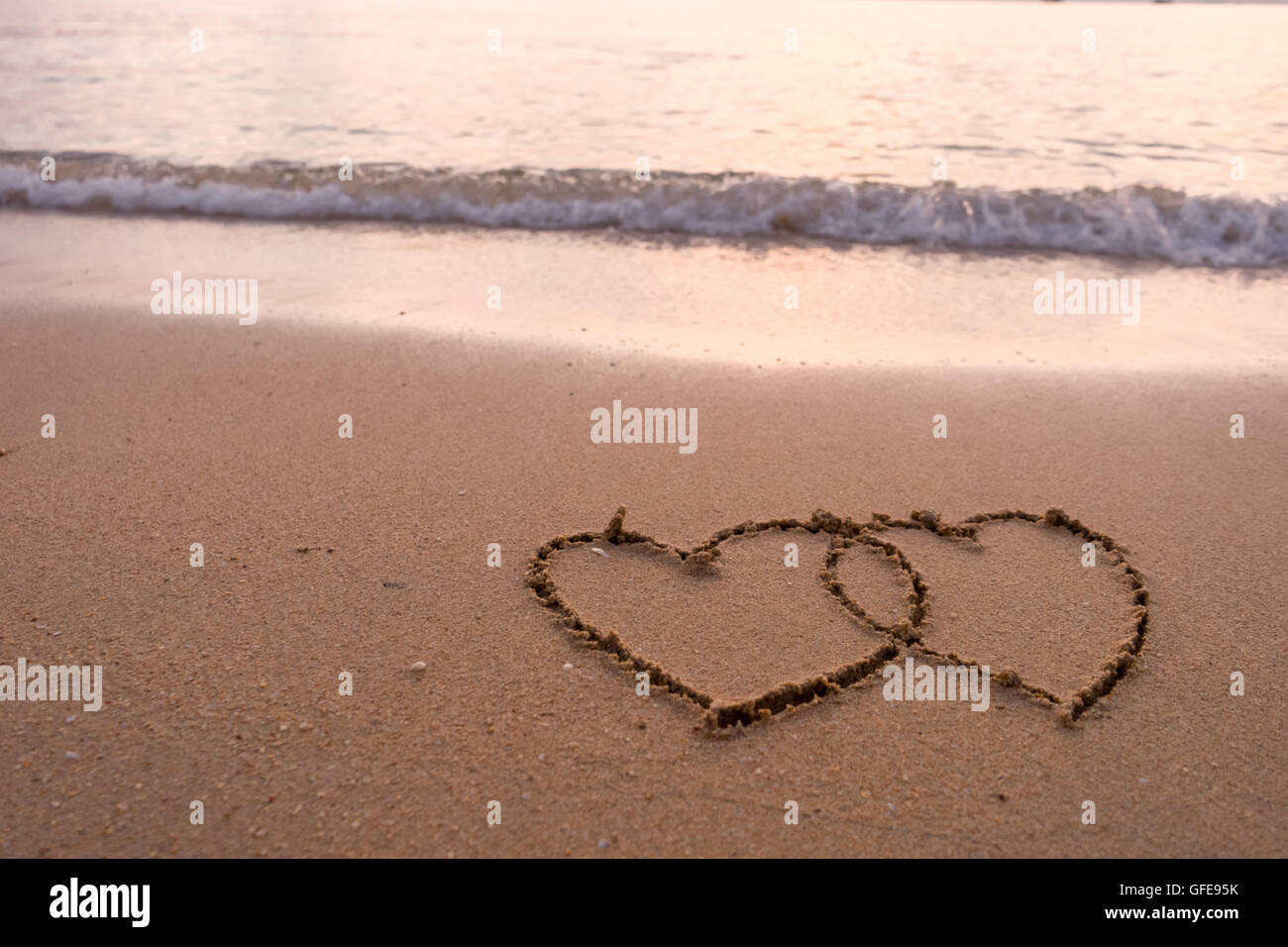 two hearts drawn in beach Stock Photo - Alamy