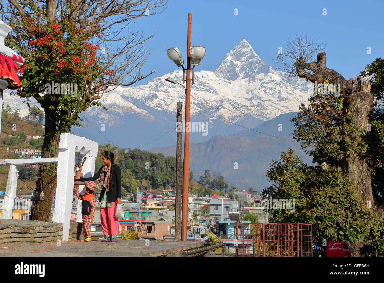 A Nepalese woman with her son ringing a bell at Bindhya Basini Temple ...