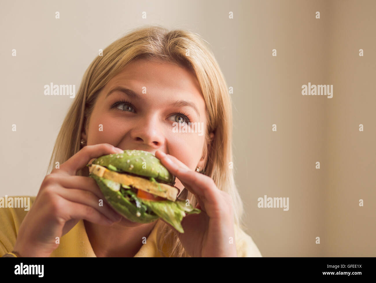 Woman eating vegan burger in restaurant Stock Photo - Alamy