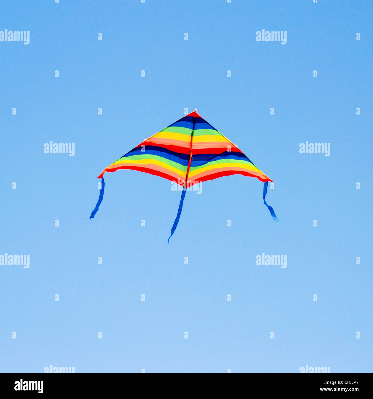 Colourful kite flying in a blue sky Stock Photo - Alamy