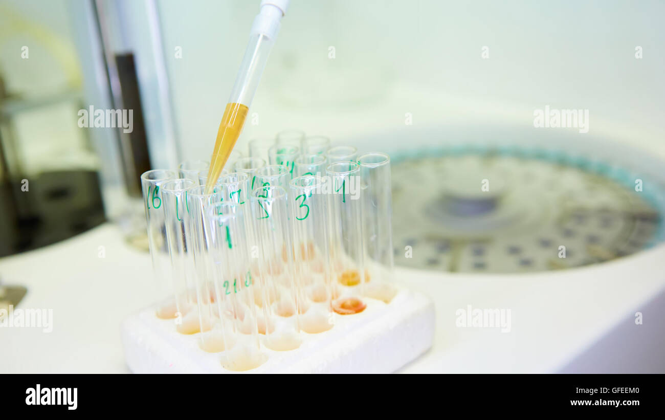 pipette dropping sample into a test tube,abstract science background ...