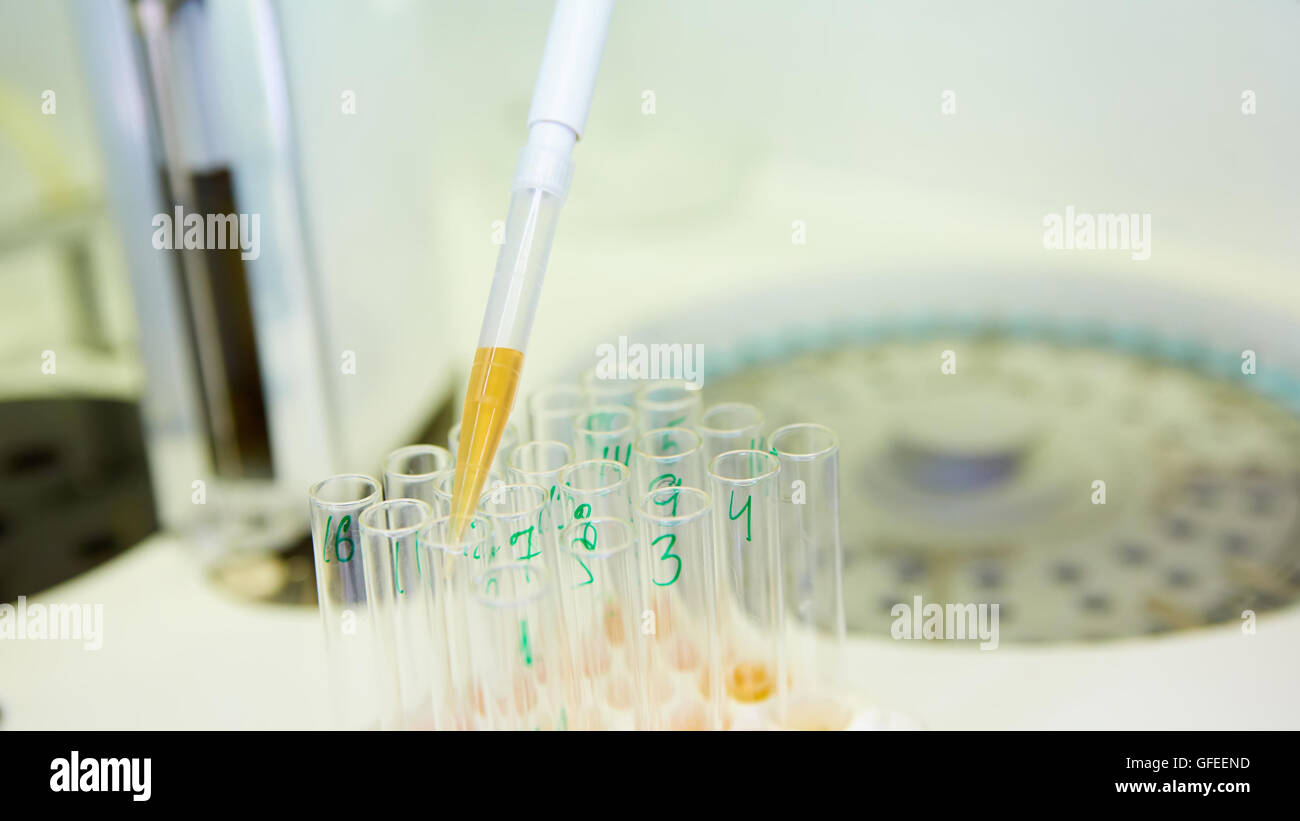 pipette dropping sample into a test tube,abstract science background ...
