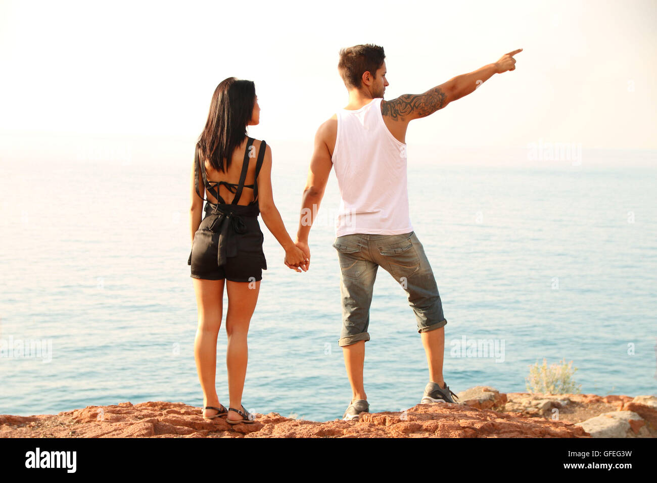 Young couple looking the ocean Stock Photo - Alamy