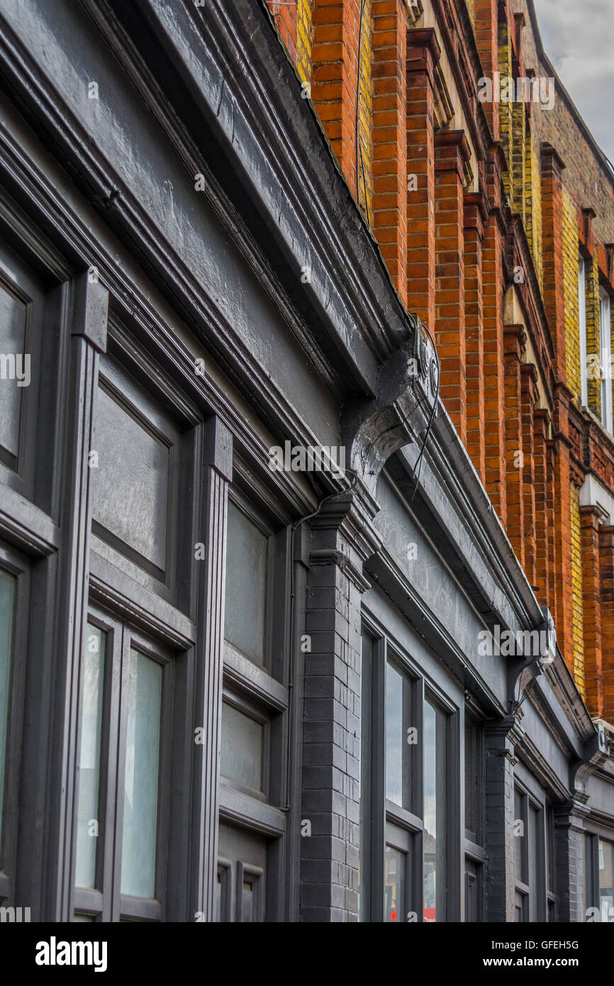 Newly refurbished grey painted shop fronts on a Victorian red brick ...