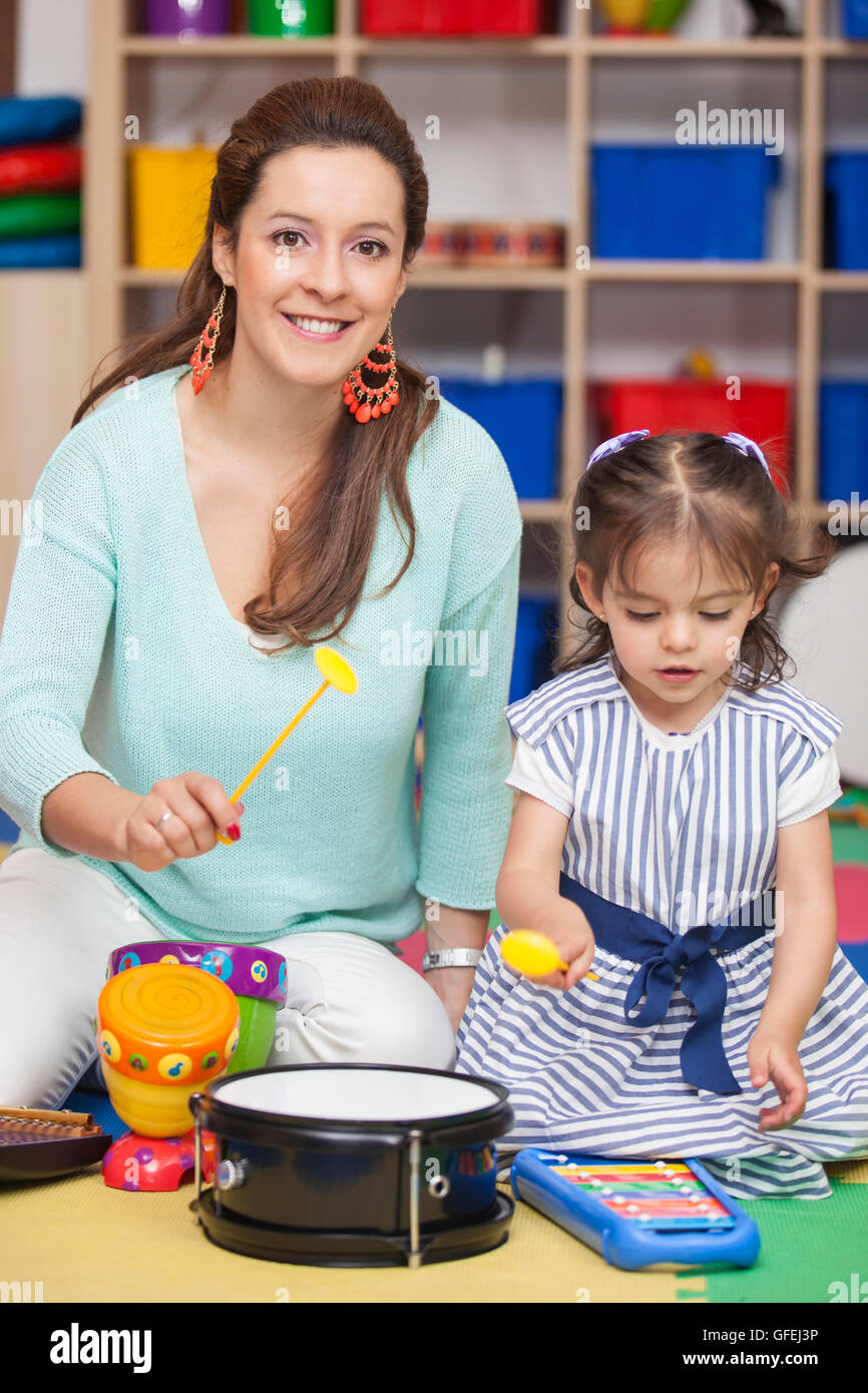 Little girl playing musical instruments with her Mom Stock Photo - Alamy