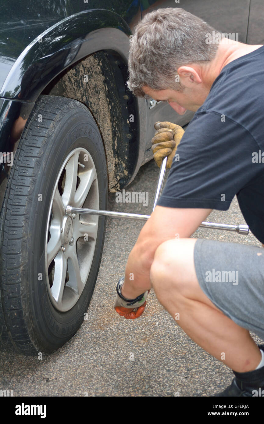 Man removing a tire on the car Stock Photo - Alamy