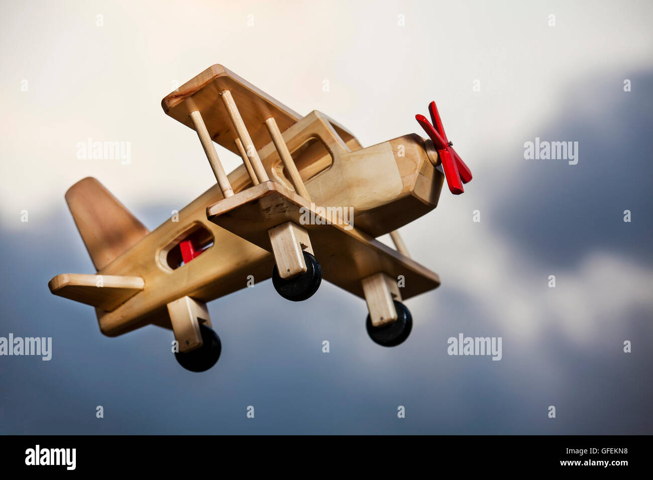 Wooden plane flying under the stormy sky - Going up Stock Photo - Alamy