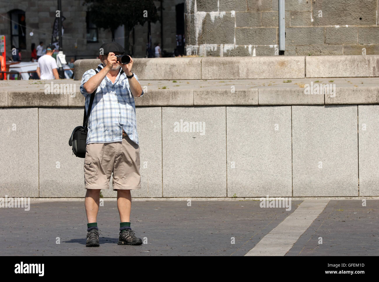 Man with a camera with a very big lens taking pictures of people. 31st ...