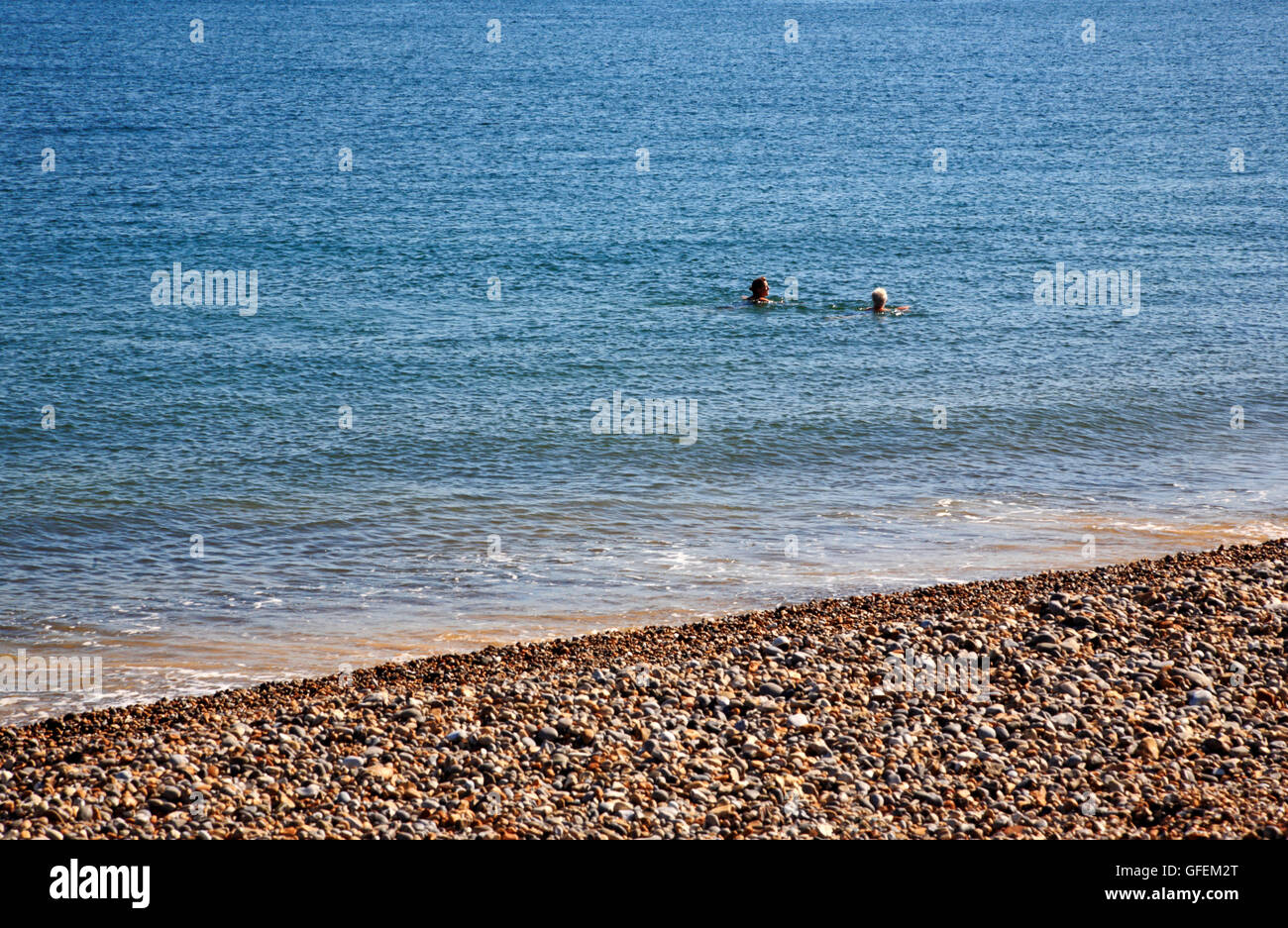 A view of two ladies swimming in a calm sea in summer at Salthouse ...